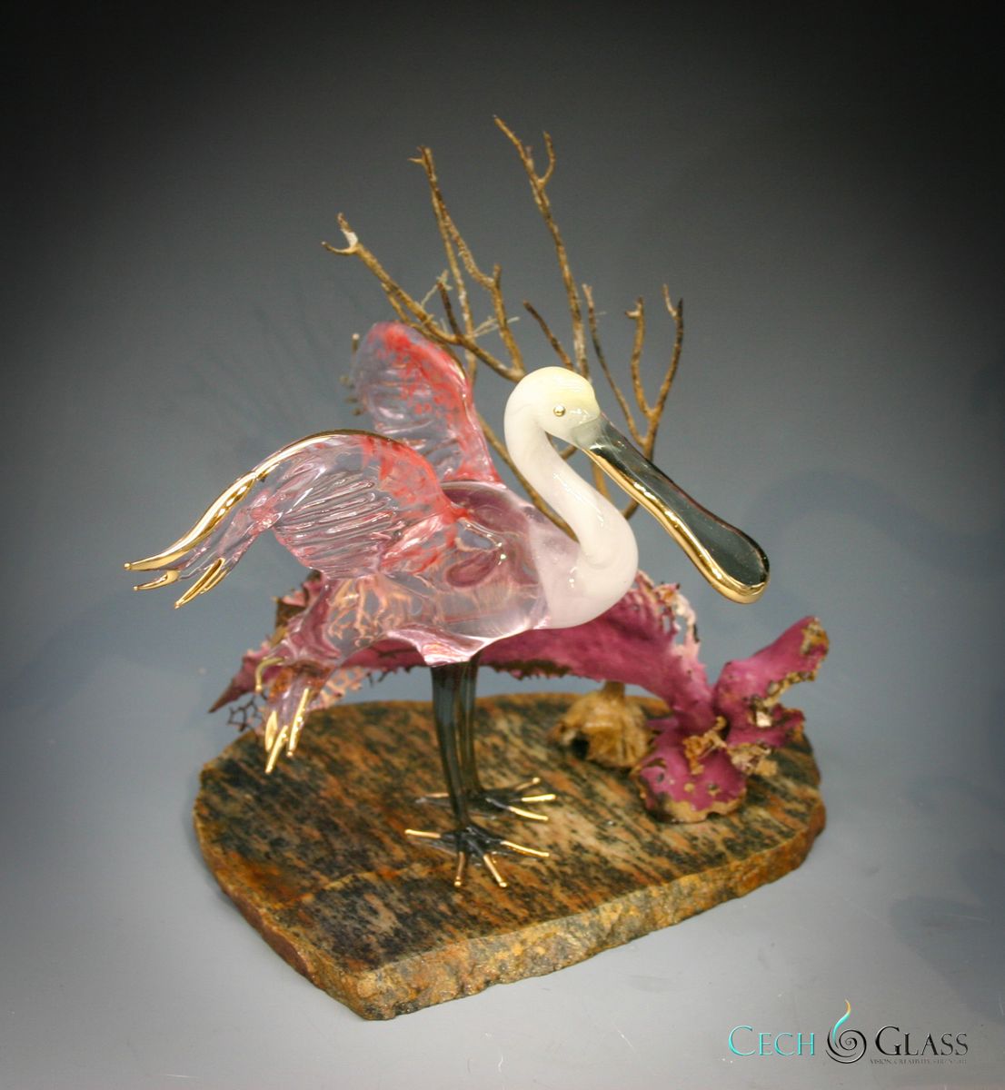Roseate spoonbill, open wings with branch on stone base