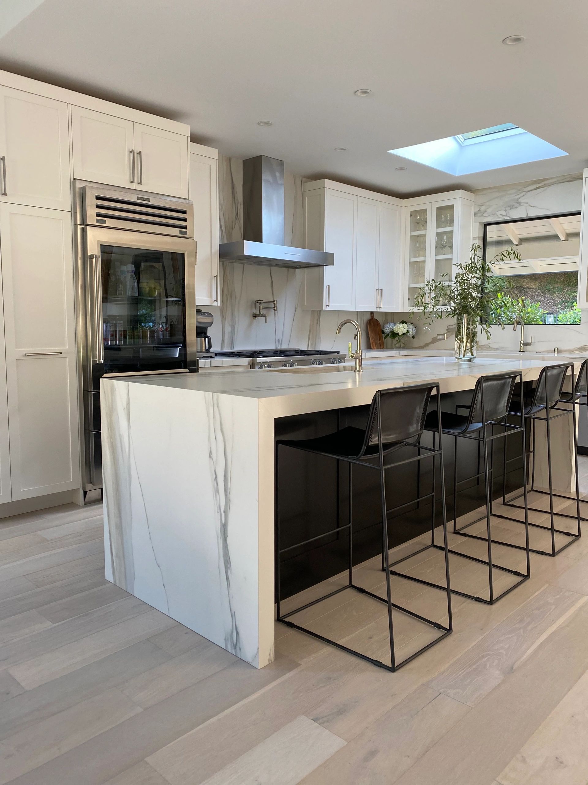 Calacatta honed porcelain slab kitchen with waterfall island